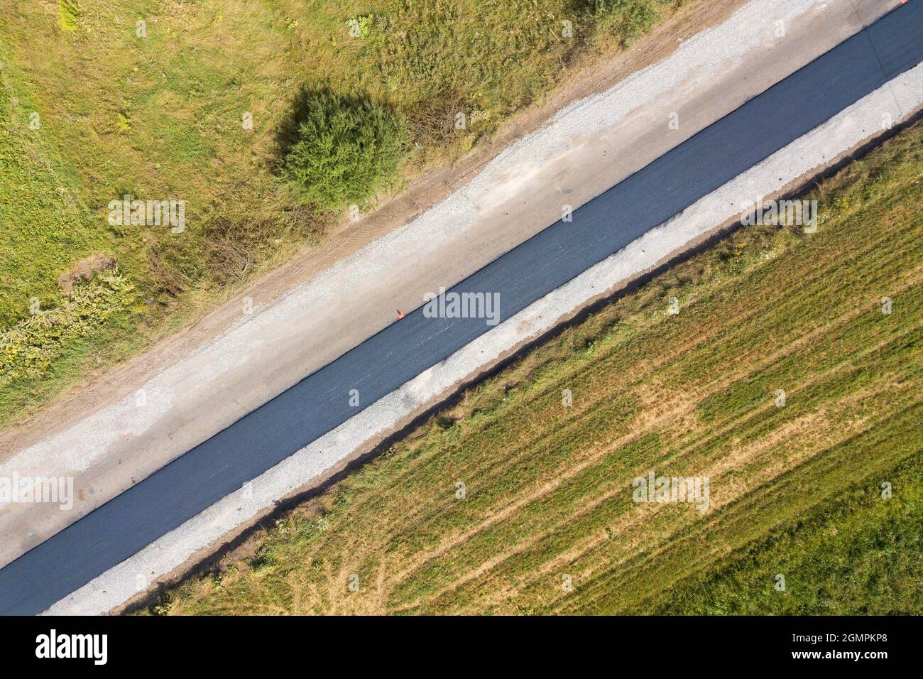 Aerial view of new road construction with newly layed black asphalt ...