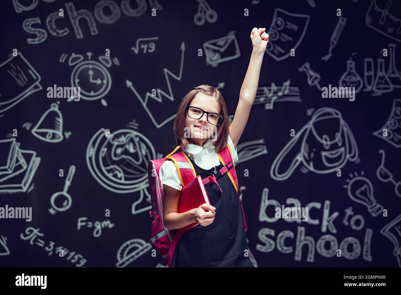 Happy pupil in glasses preparing to go to school holding book raising ...