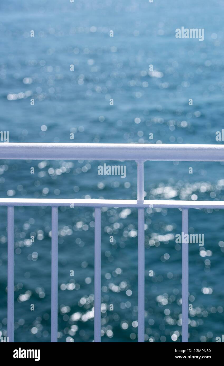 Safety railings on the deck of a ferry boat with the sea in the ...
