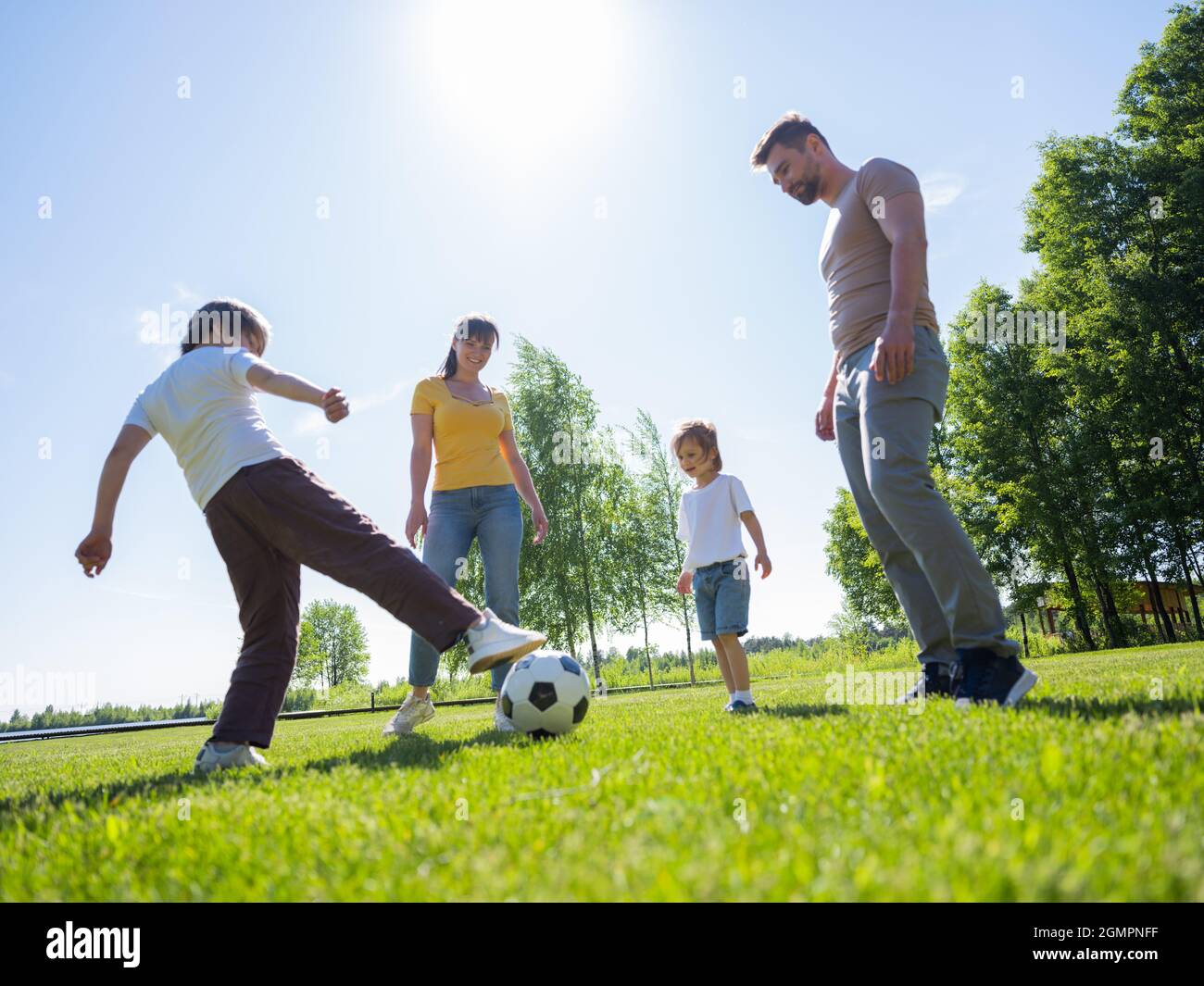 Parents and kids playing soccer football ball in summer park Stock ...