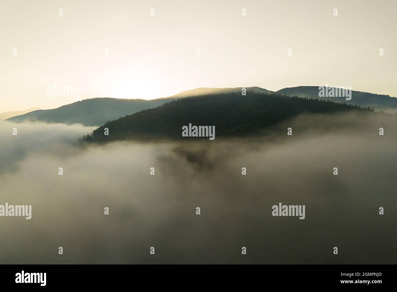 Aerial view of vibrant sunset over white dense foggy clouds with ...