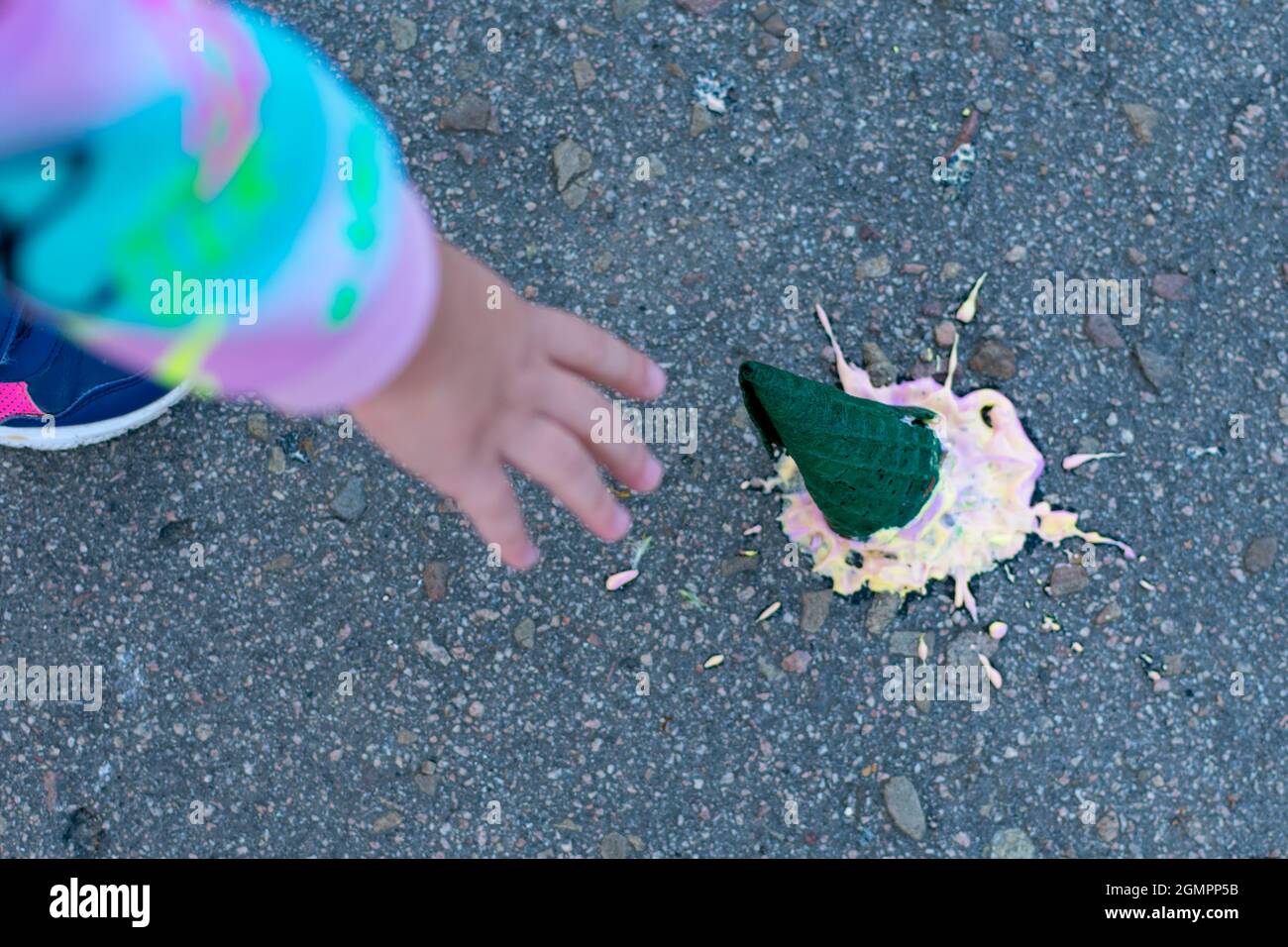 The child's hand reaches for the ice cream that has fallen on the ...