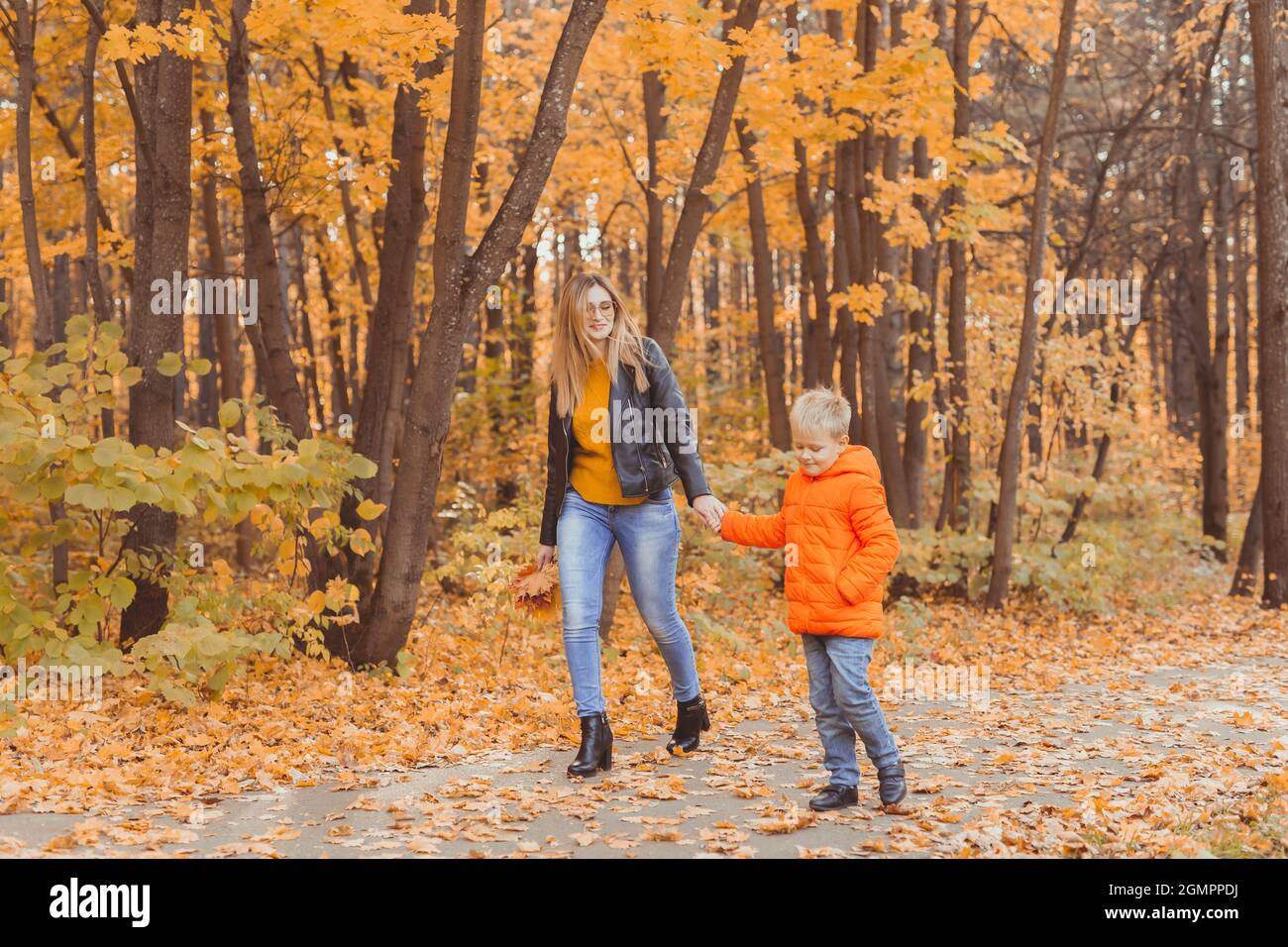 Mother and son walking in the fall park and enjoying the beautiful ...