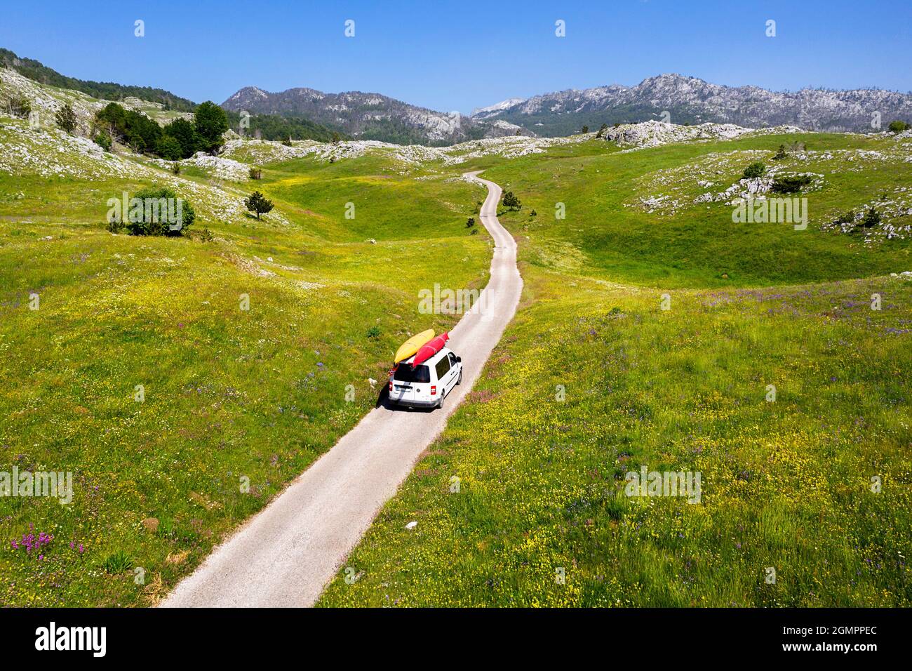 Aerial view of a car with tourists exploring beautiful lukavica meadow ...