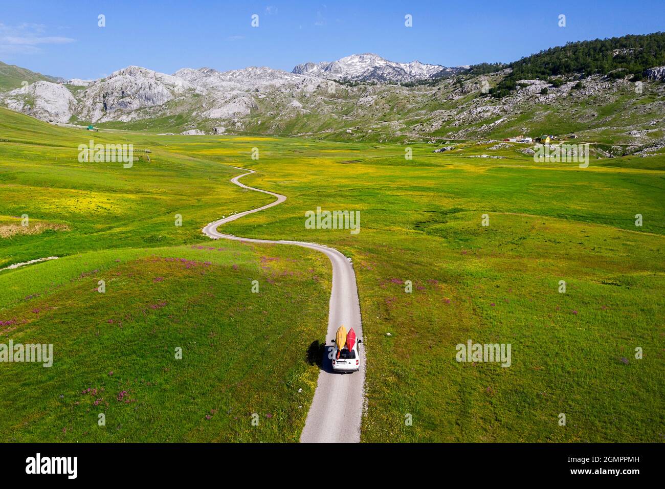 Aerial view of a car with tourists exploring beautiful lukavica meadow ...
