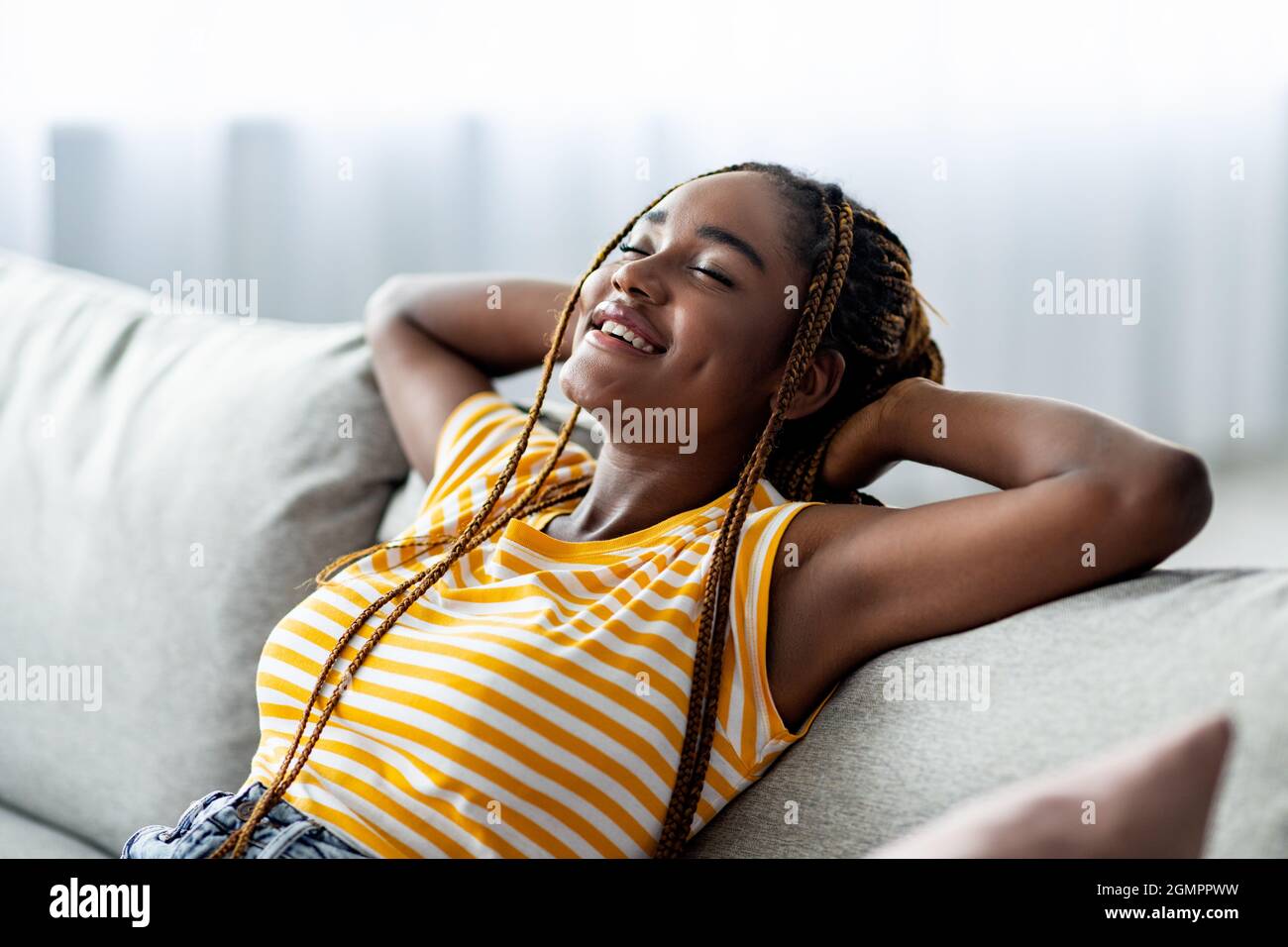 Closeup portrait of black woman relaxing on couch at home Stock Photo ...