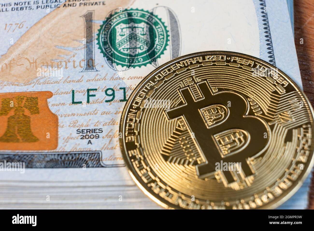 Close up of metal shiny bitcoin crypto currency coin on US dollar bills ...