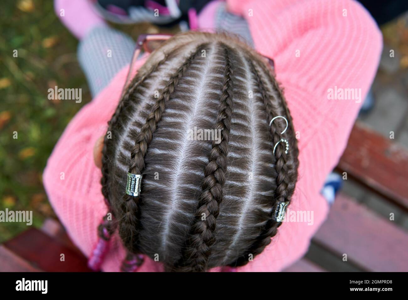 Selective of afro braids of a female sitting on the bench in the park ...