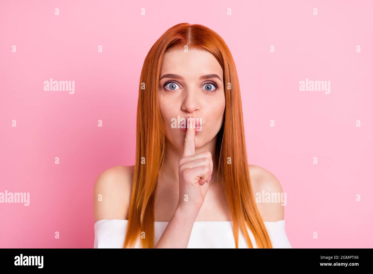Portrait of attractive amazed mysterious red-haired girl showing shh ...