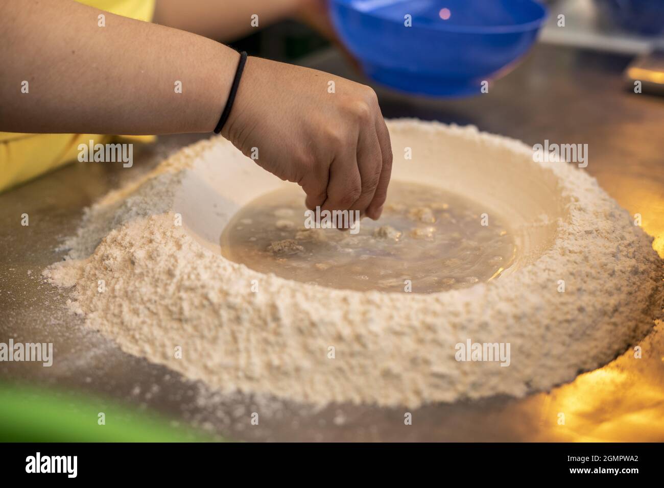 Closeup shot of a woman's hand cooking using water and flour and making ...