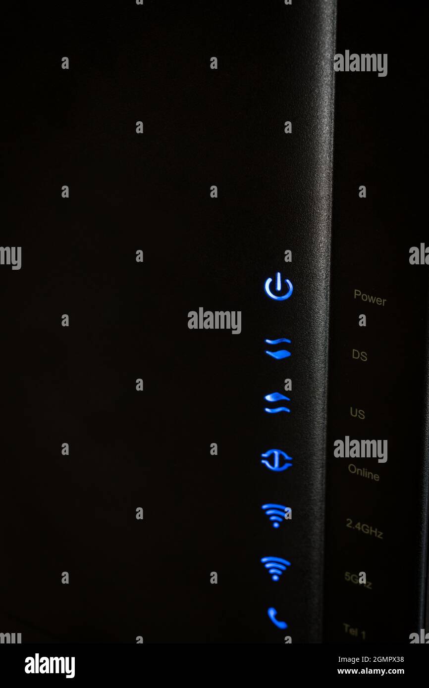 Black internet modem with blue light buttons of power and wifi symbol ...