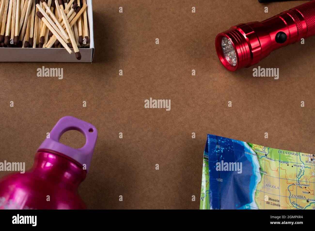 Red flashlight, wooden matches and a map for a forest trip on a wooden ...