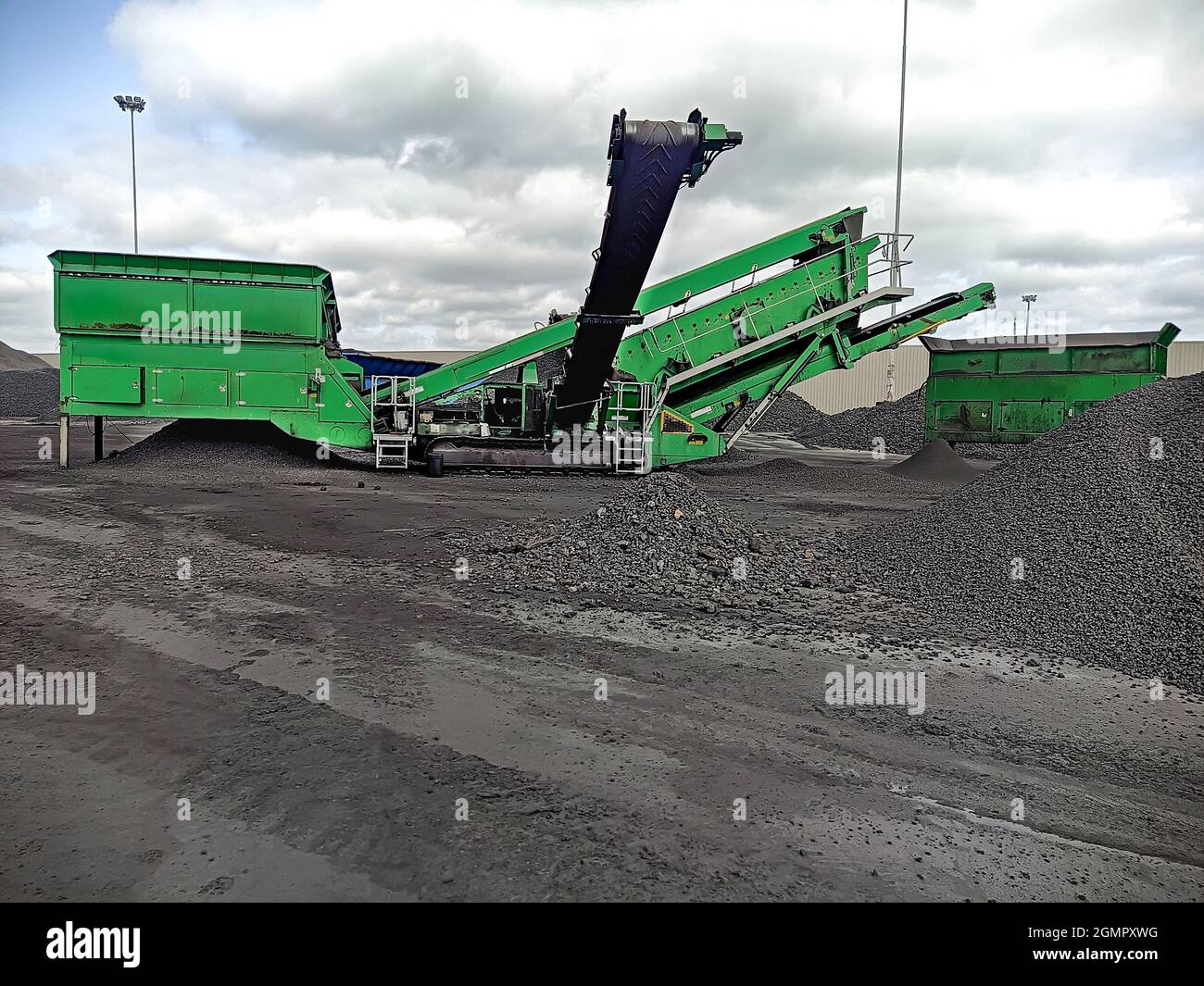 Mechanized loading of bulk cargo. Heaps of gravel on the dock and a ...