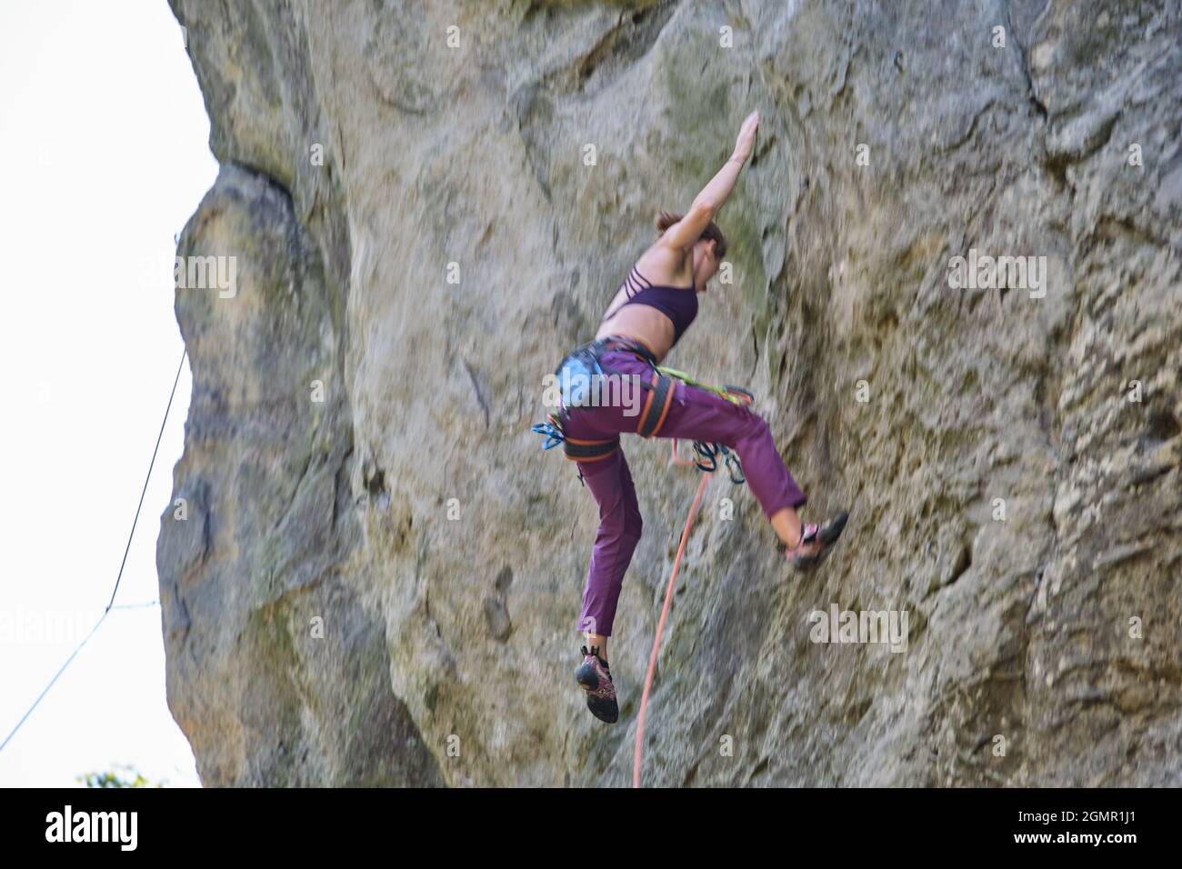 Motion blur image of young woman climber falling down after failed ...