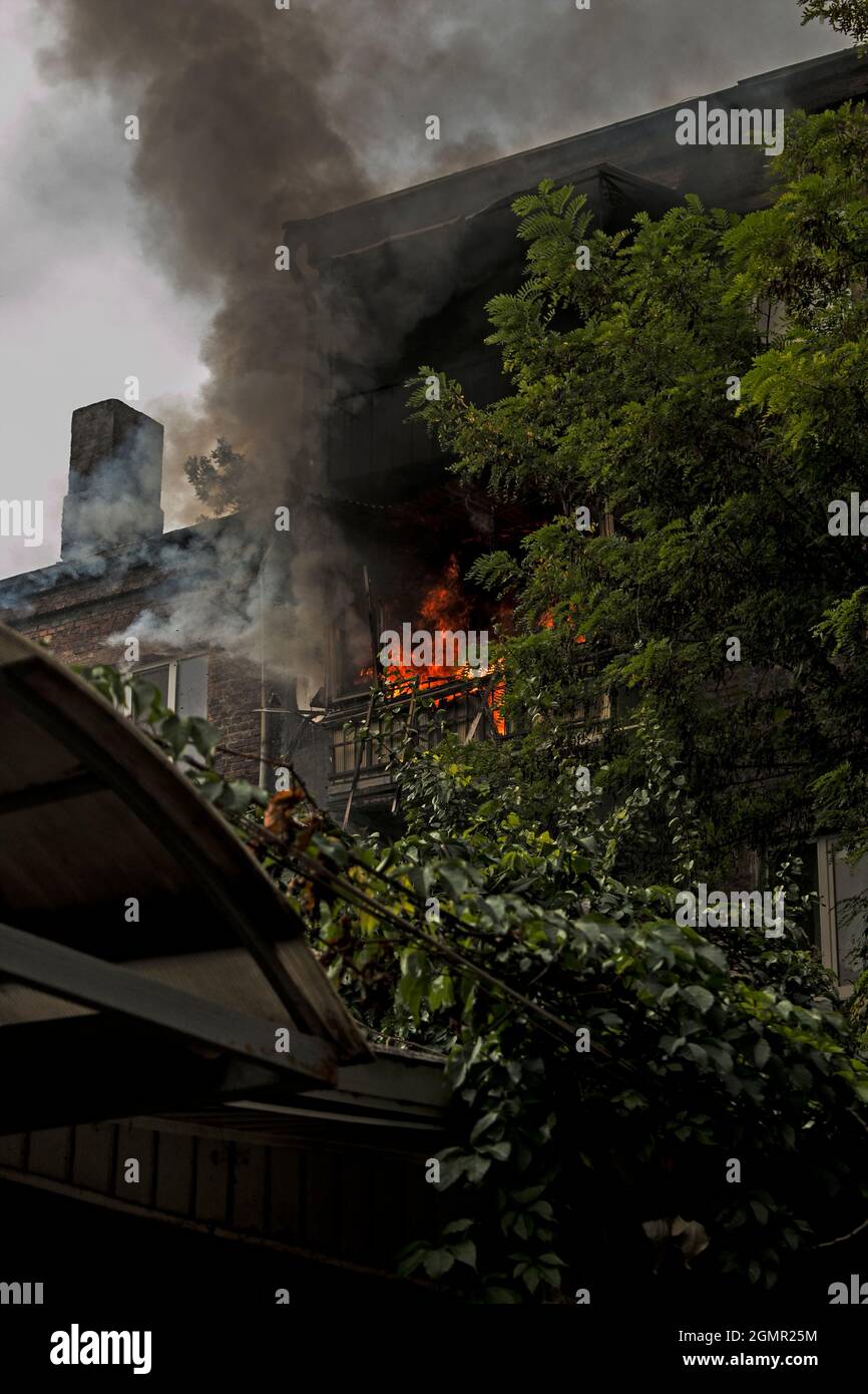Fire on the balcony of a five-story building. Fire and black clouds of ...