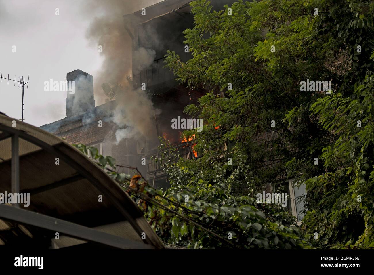 Fire on the balcony of a five-story building. Fire and black clouds of ...