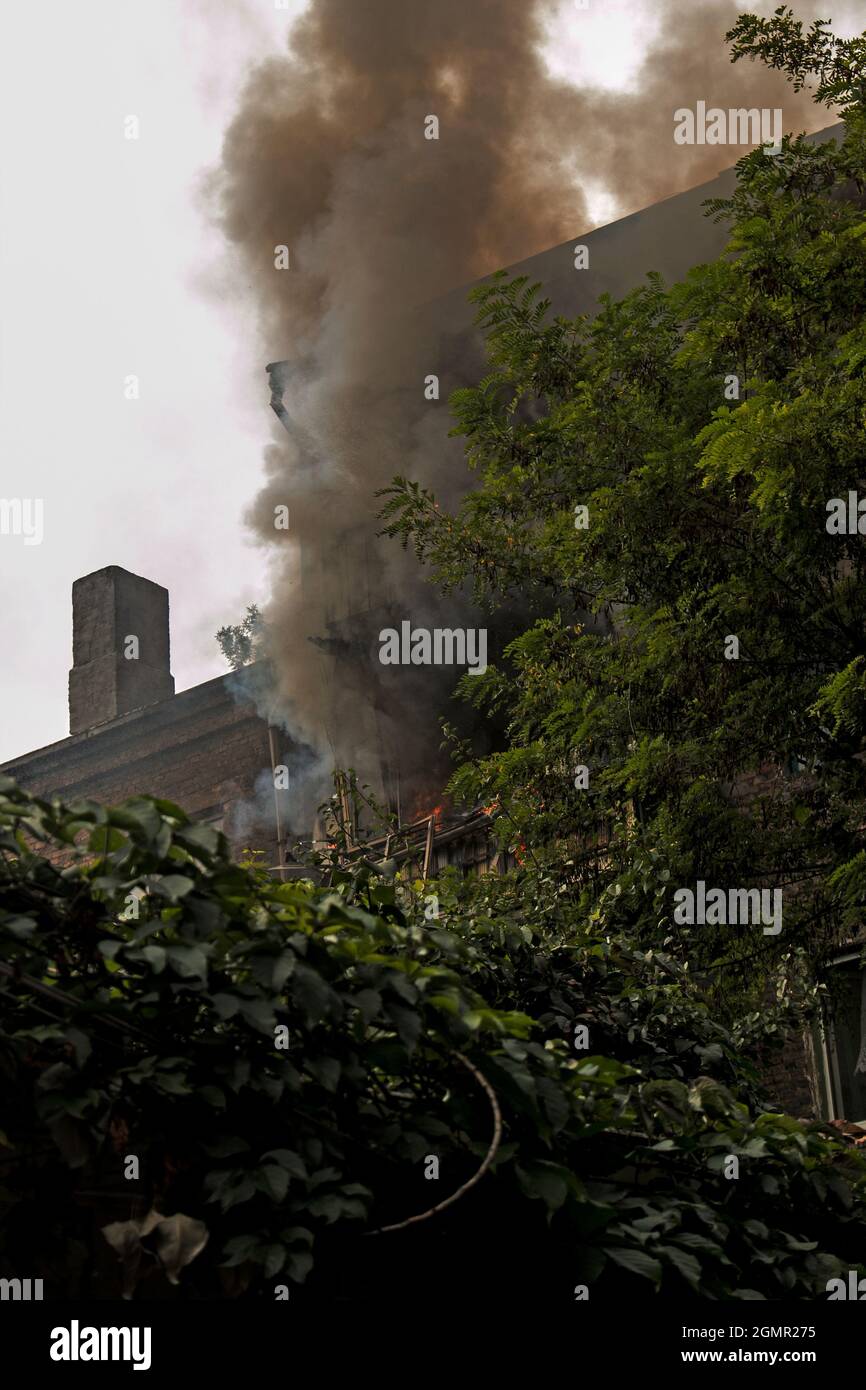 Fire on the balcony of a five-story building. Fire and black clouds of ...