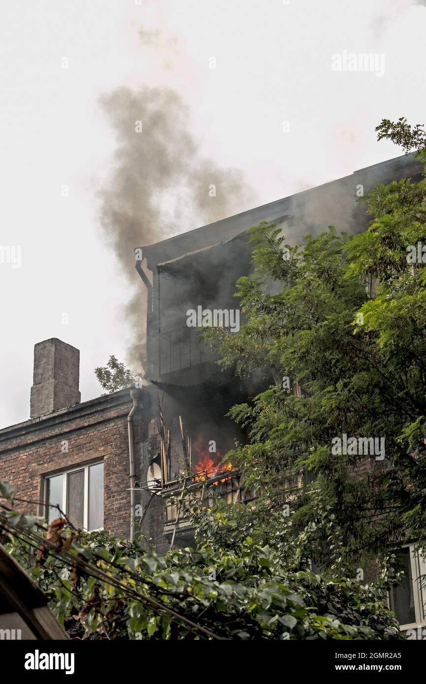 Fire on the balcony of a five-story building. Fire and black clouds of ...