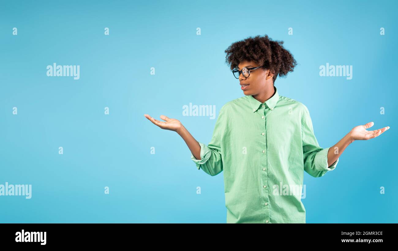 Making choice. Teen black guy making scales with his empty hands ...