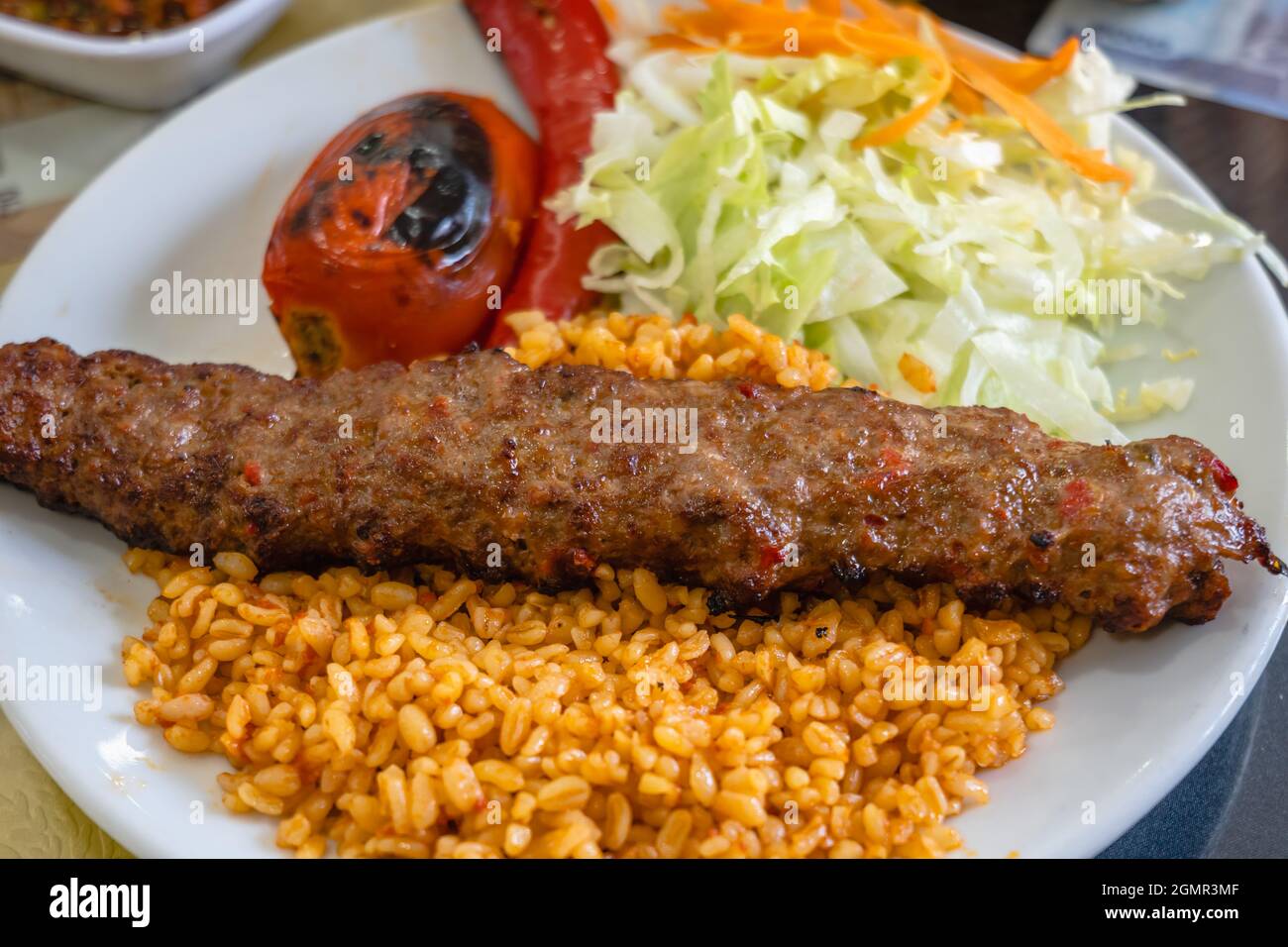 Adana Kebab, traditional Turkish cuisine with kebab meat, vegetables on ...