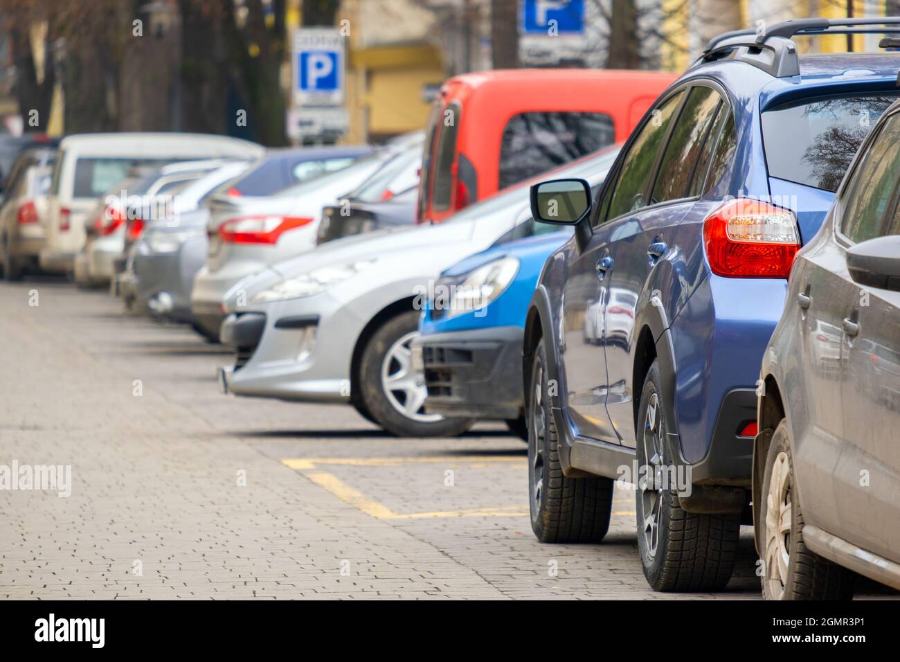 Cars parked in a row on a city street side Stock Photo - Alamy