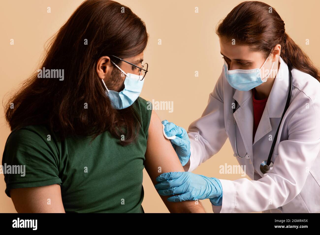 Nurse in face mask disinfecting skin before injection Stock Photo - Alamy