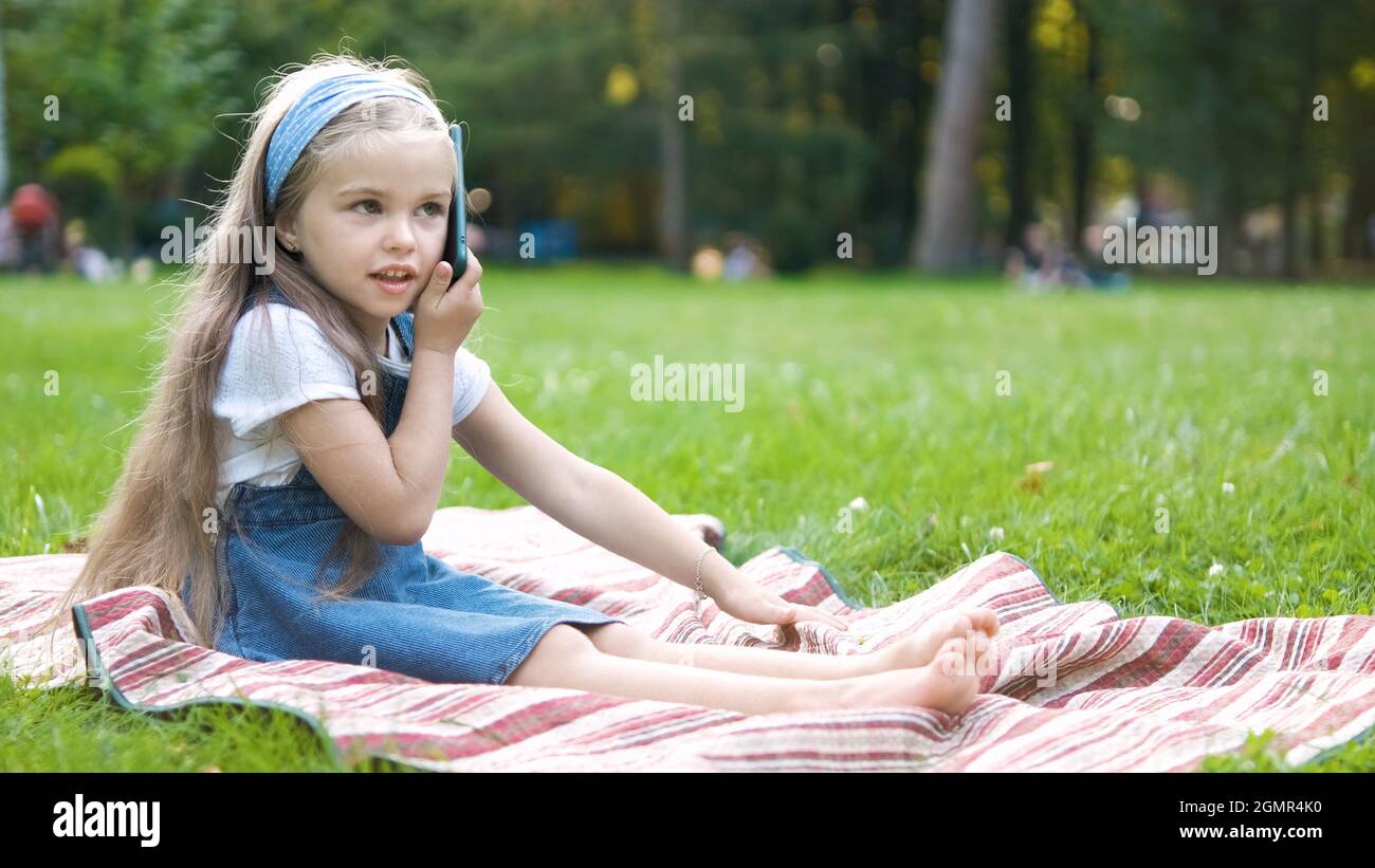 Pretty little child girl having conversation on her mobile phone in ...