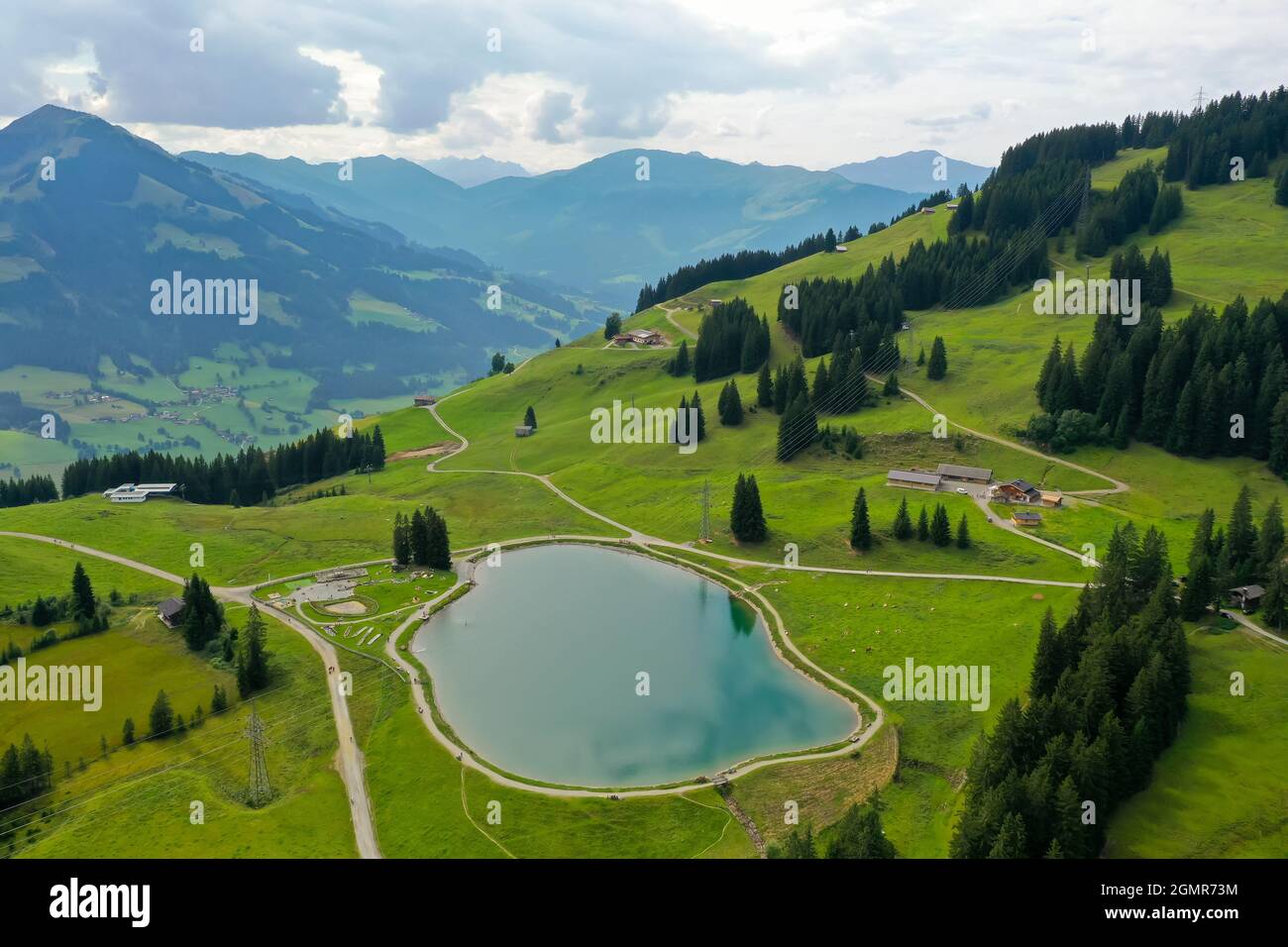 Landscape of the Filzalmsee surrounded by hills covered in greenery in ...