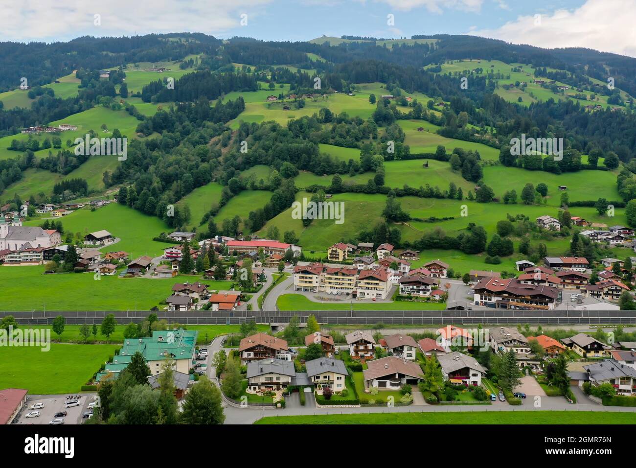 Landscape of a town surrounded by hills covered in greenery in Brixen ...