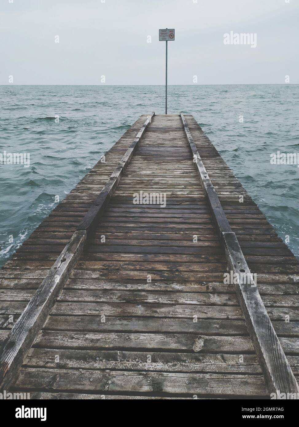 Dramatic vertical shot of a pier leading to the sea Stock Photo - Alamy