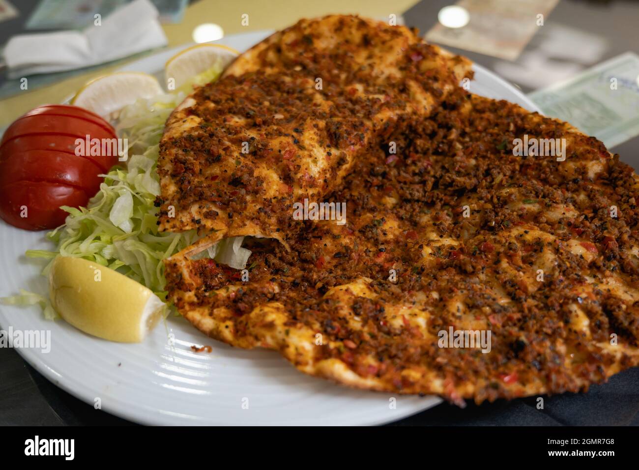 Lahmacun, known as Turkish pizza, on plate in Turkish restaurant, a ...