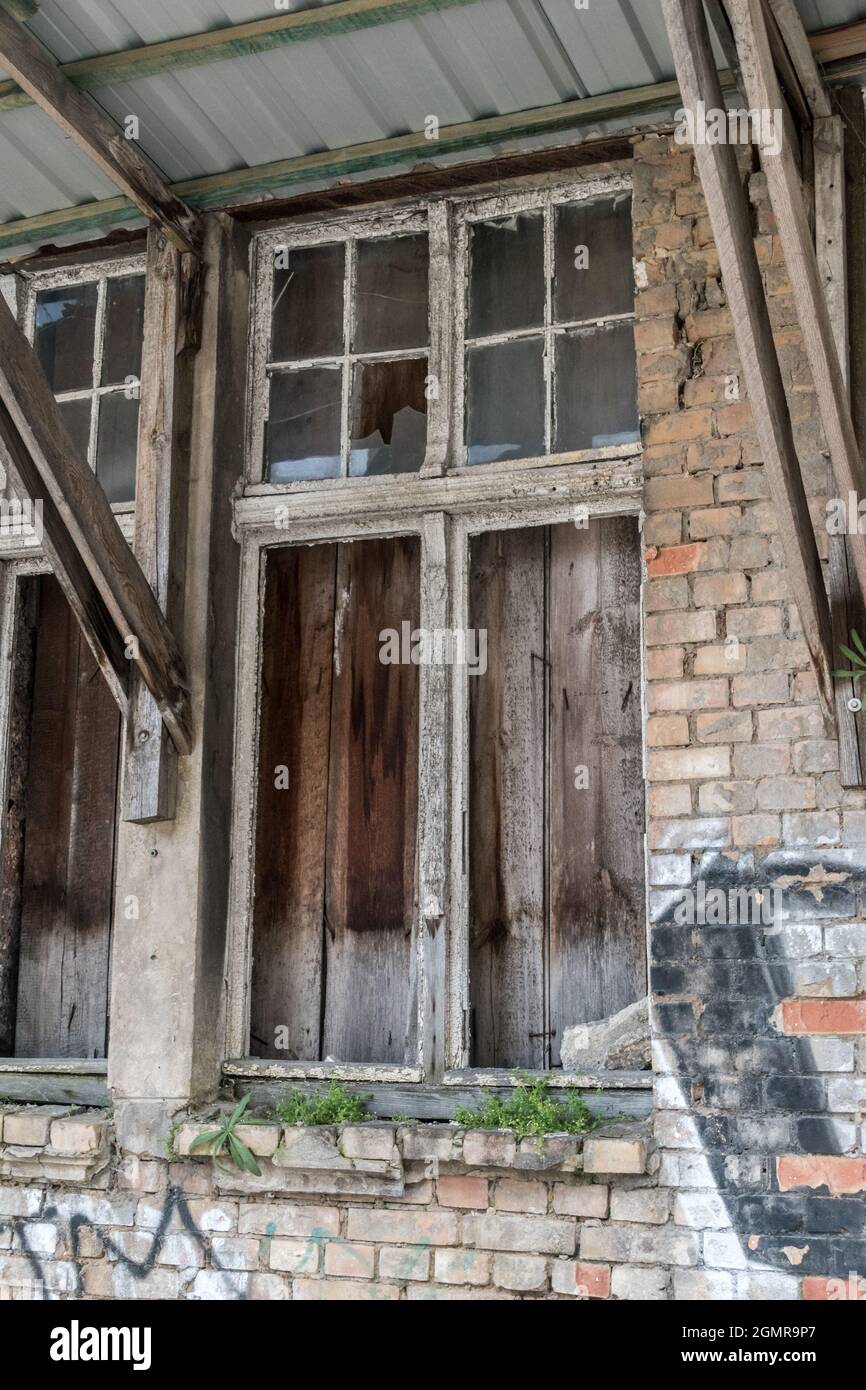Broken and boarded-up window of the old abandoned house Stock Photo - Alamy