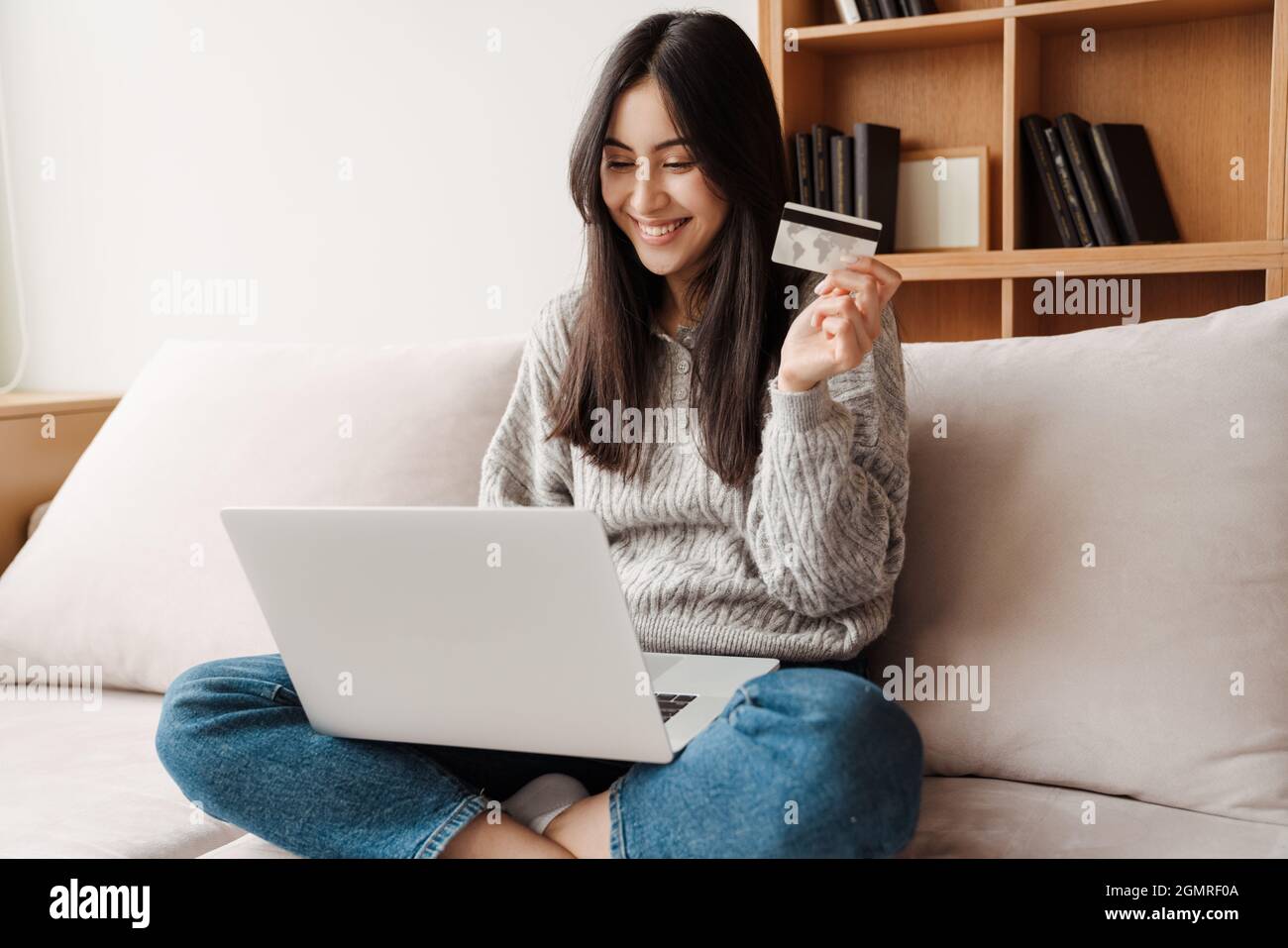 Happy young attractive woman shopping online via laptop computer, using ...