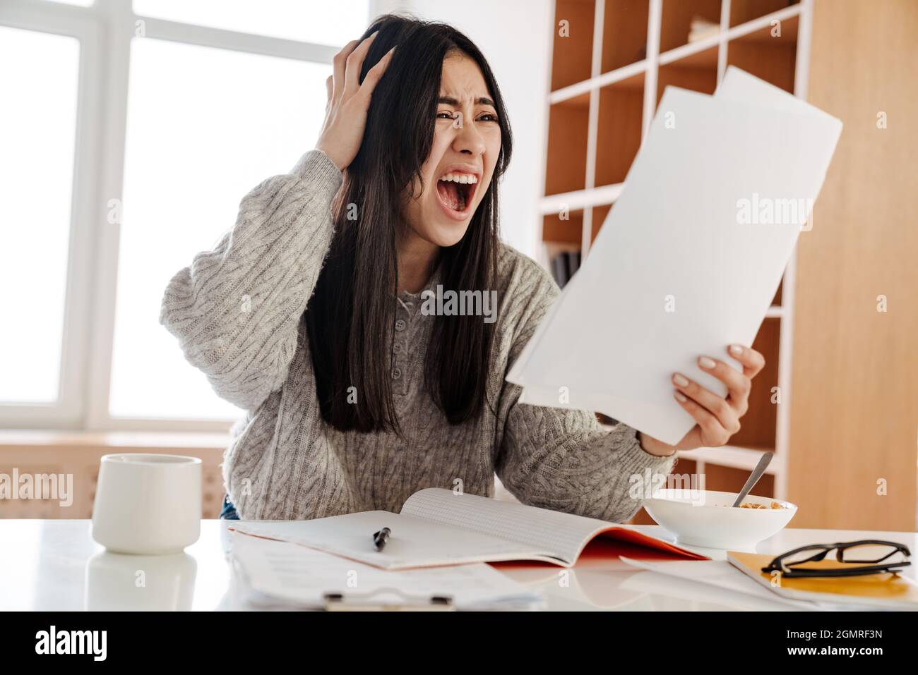 Shocked devastated young smart woman studying while having healthy ...