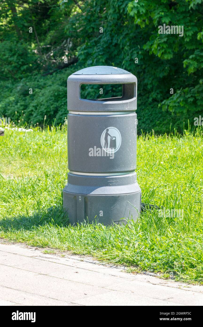 Green garbage bin next to pavement. Street trash can Stock Photo - Alamy