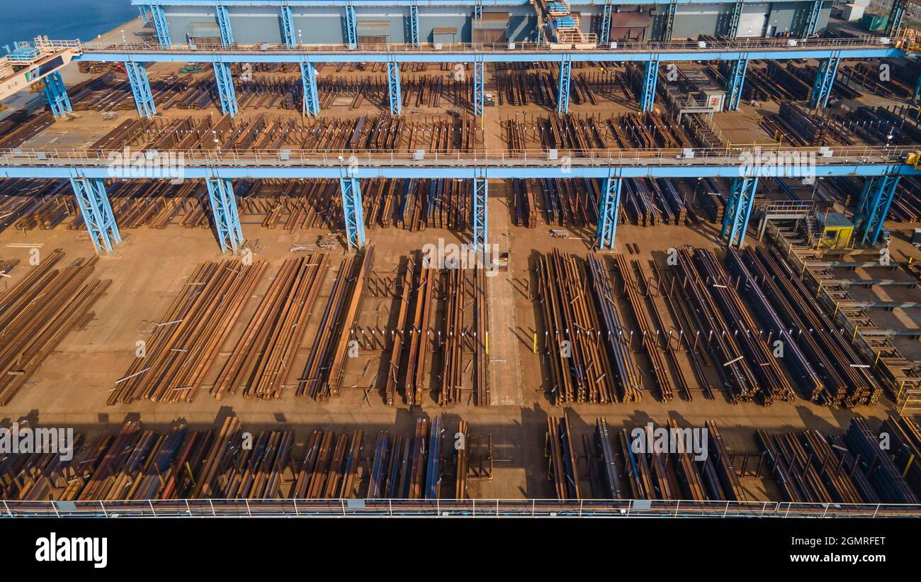 Steel beams, rusty and clean, by the warehouse in industrial estate ...