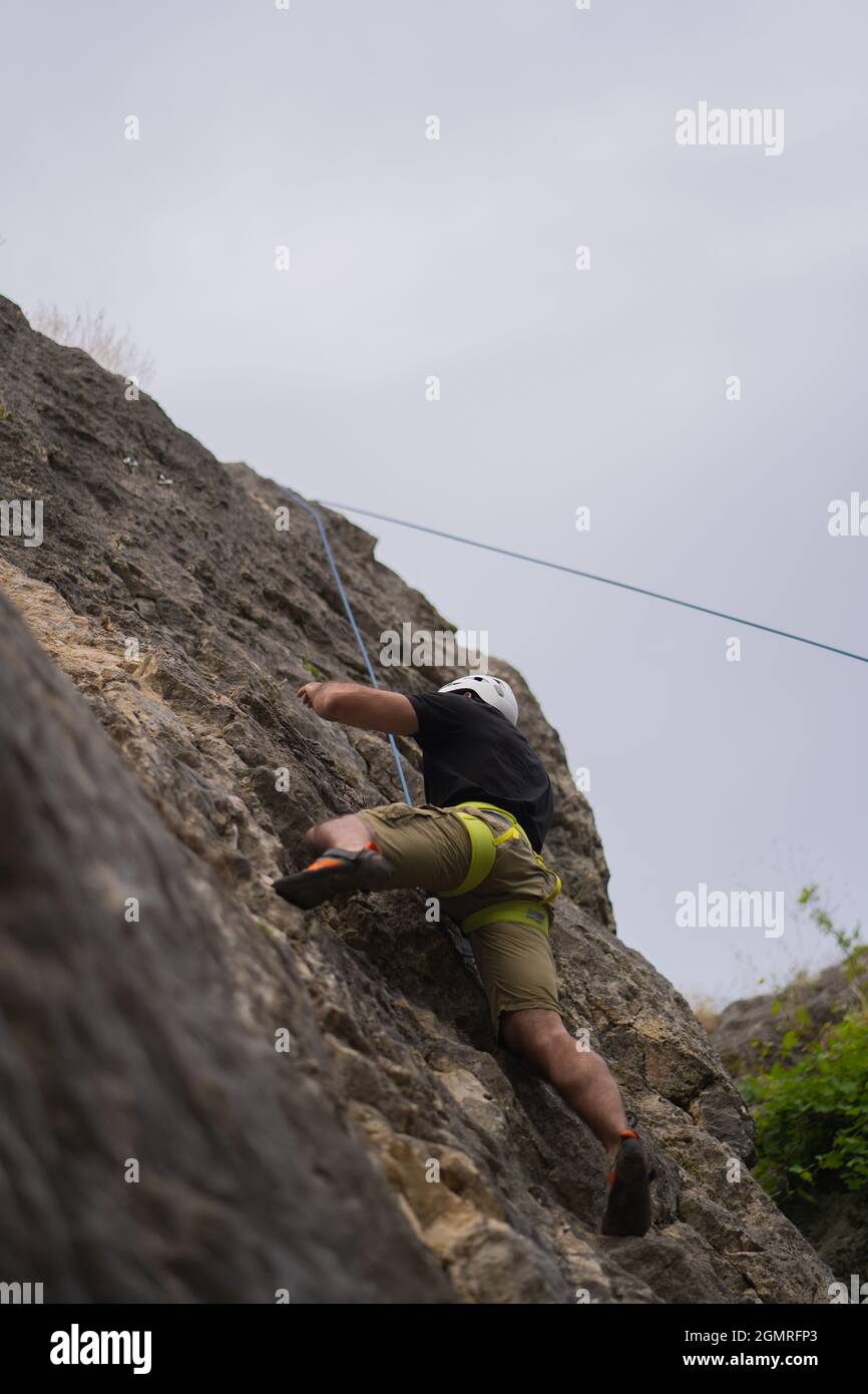 Handsome and fit guy is climbing while trying to reach the top Stock ...
