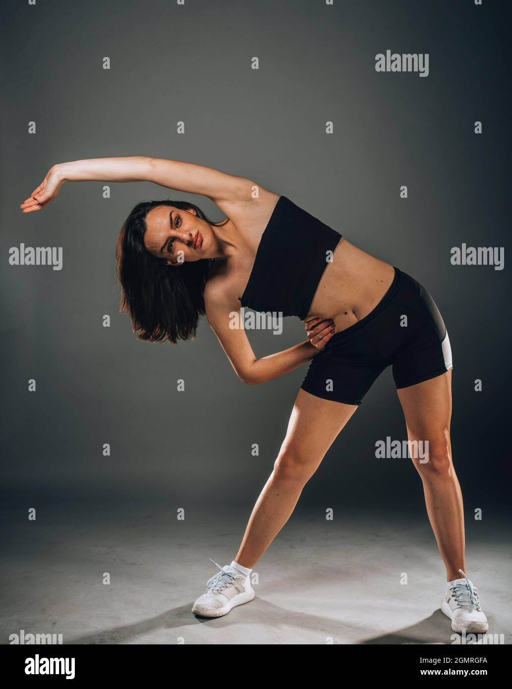 Working her core muscles. Full length of young beautiful woman in ...