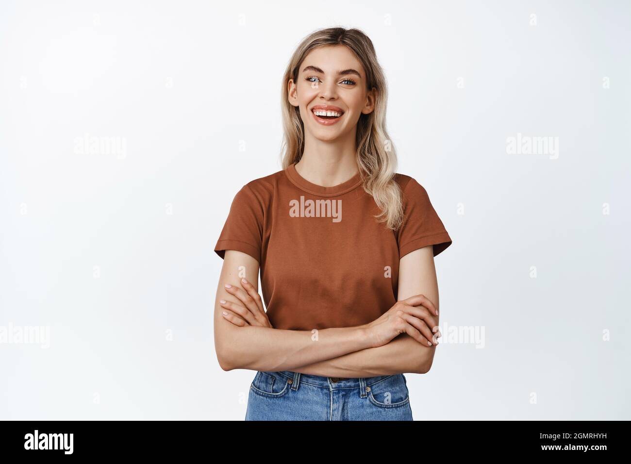 Pretty young woman laughing and smiling, cross arms on chest and ...