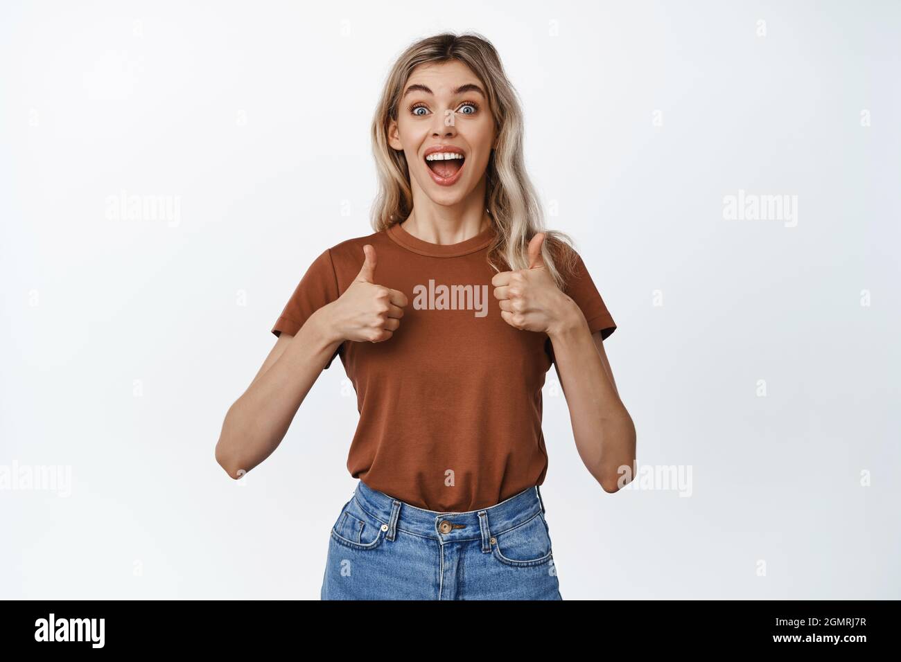 Excited smiling woman showing thumbs up, positive reaction to something ...