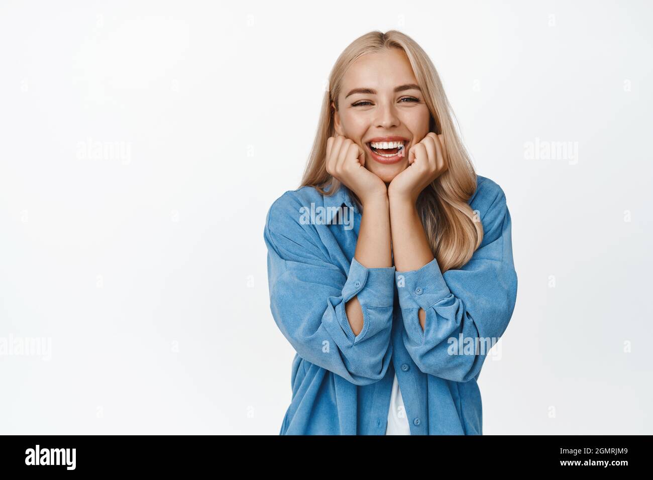 Beautiful young woman smiling and laughing, lean face on hands and ...