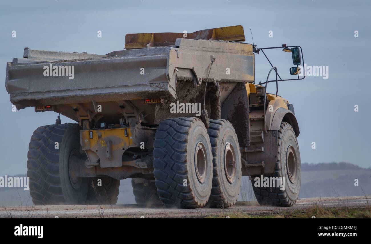 a yellow Volvo A40E articulated dump truck earth mover driving across ...