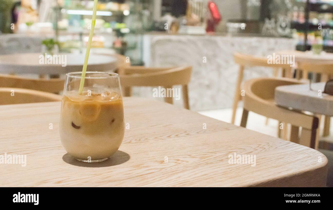 Glass of ice latte drink on a cafe table Stock Photo - Alamy