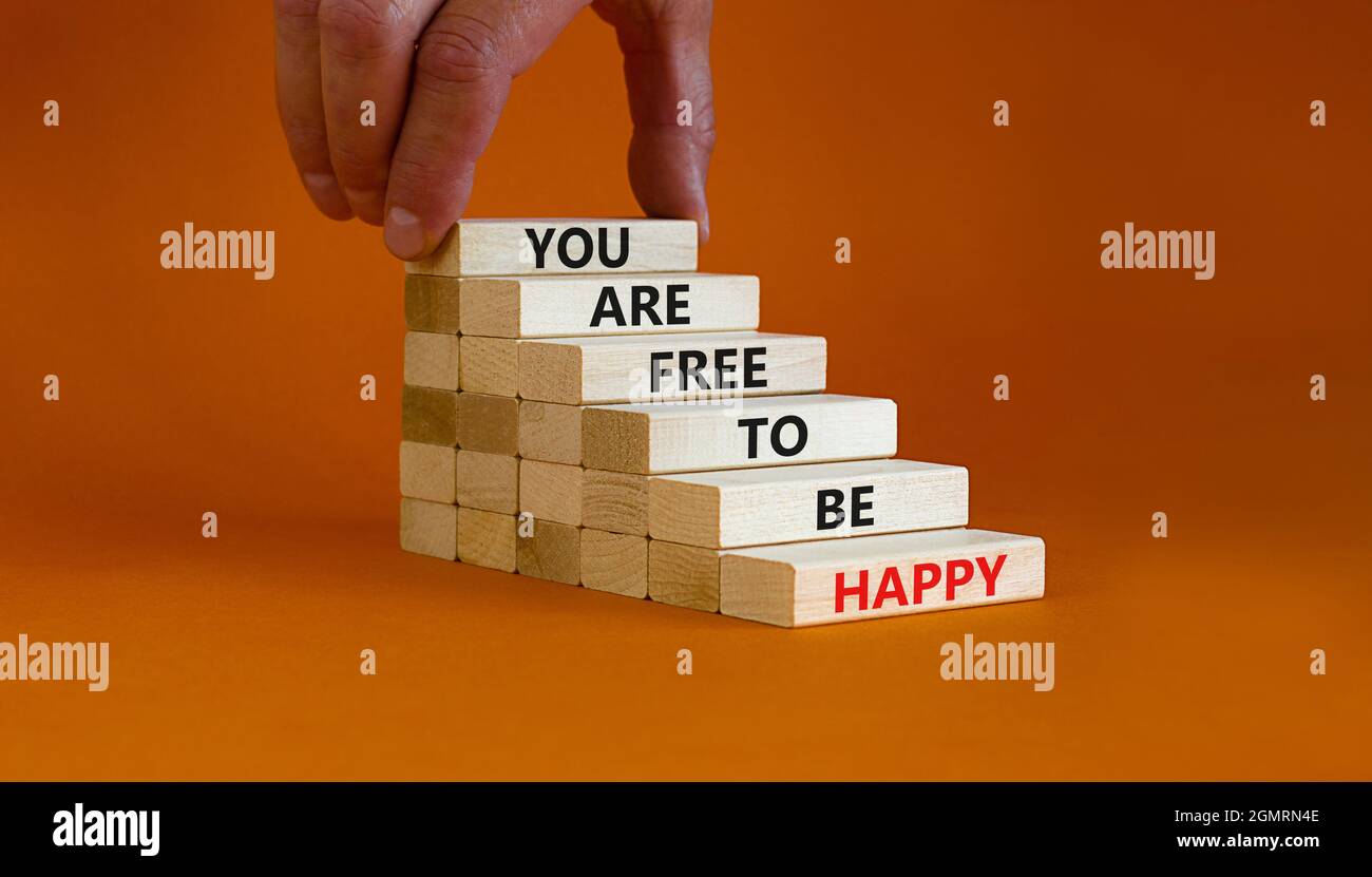 You are free to be happy symbol. Businessman hand. Wooden blocks tower ...