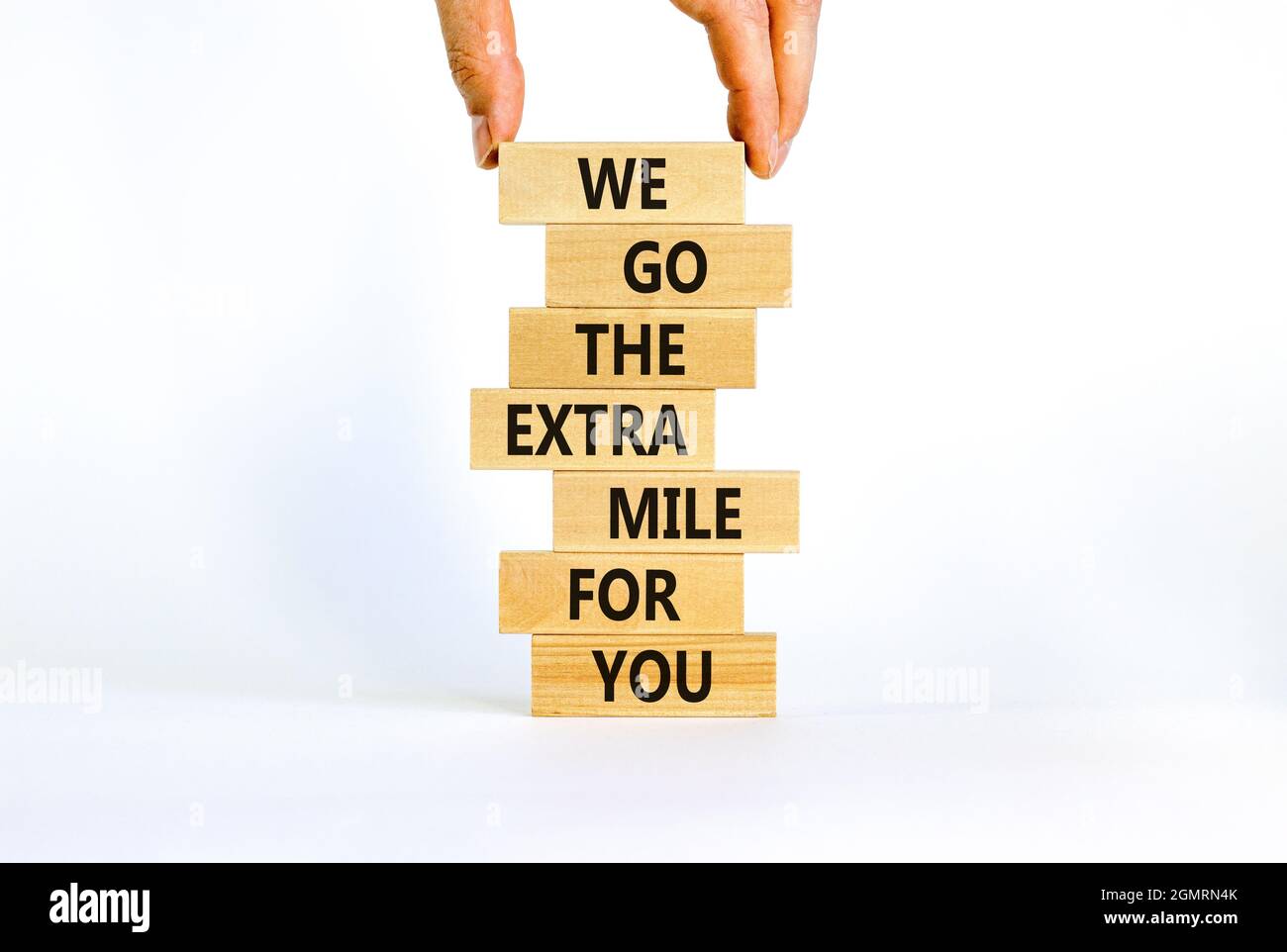 Go the extra mile symbol. Wooden blocks with words 'We go the extra ...