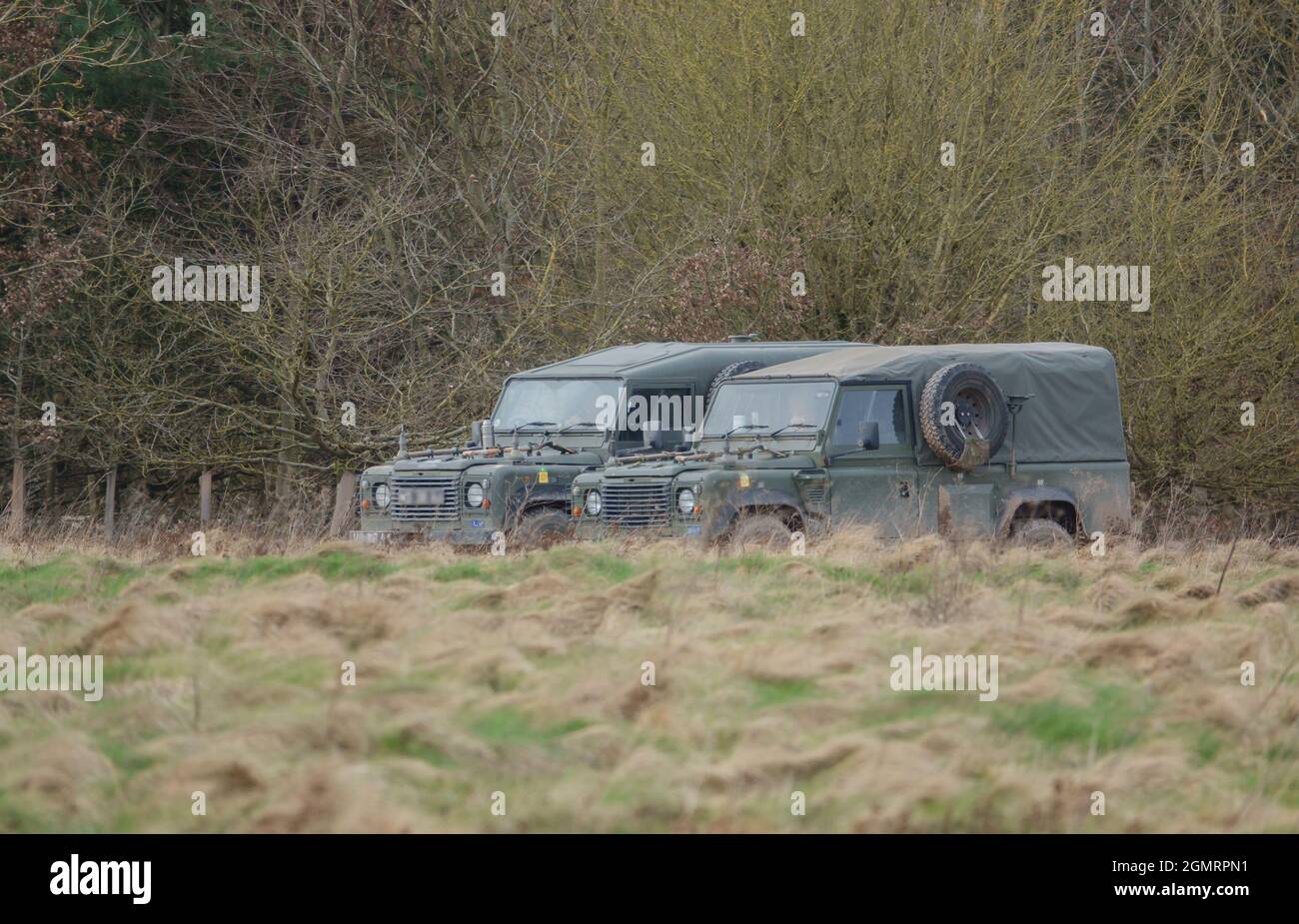a pair of British army utility medium vehicle Land Rover Defender Wolf ...