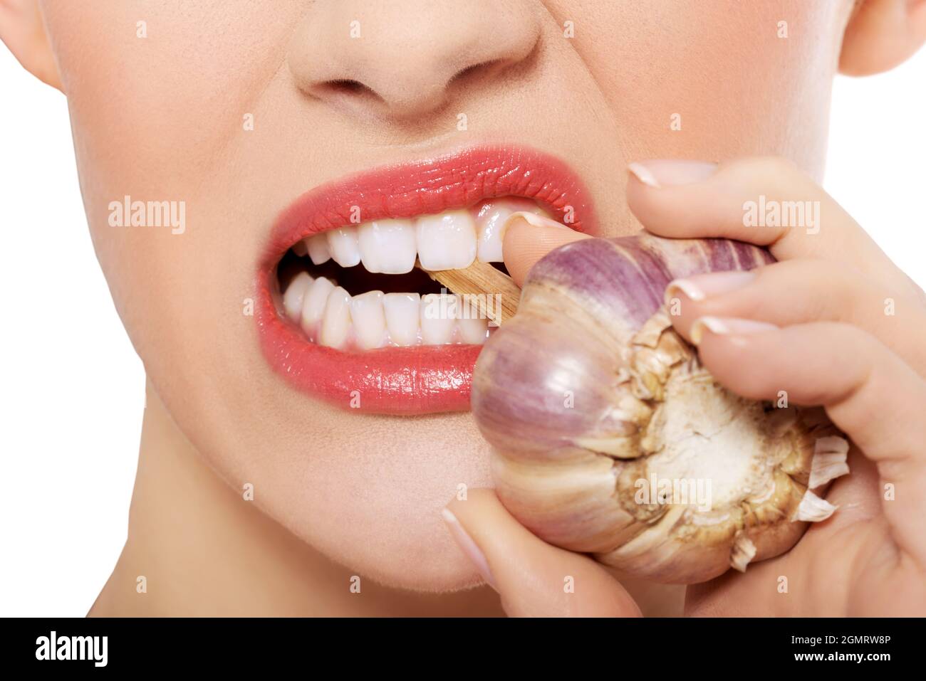 Closeup shot of a woman biting garlic isolated on a white background ...