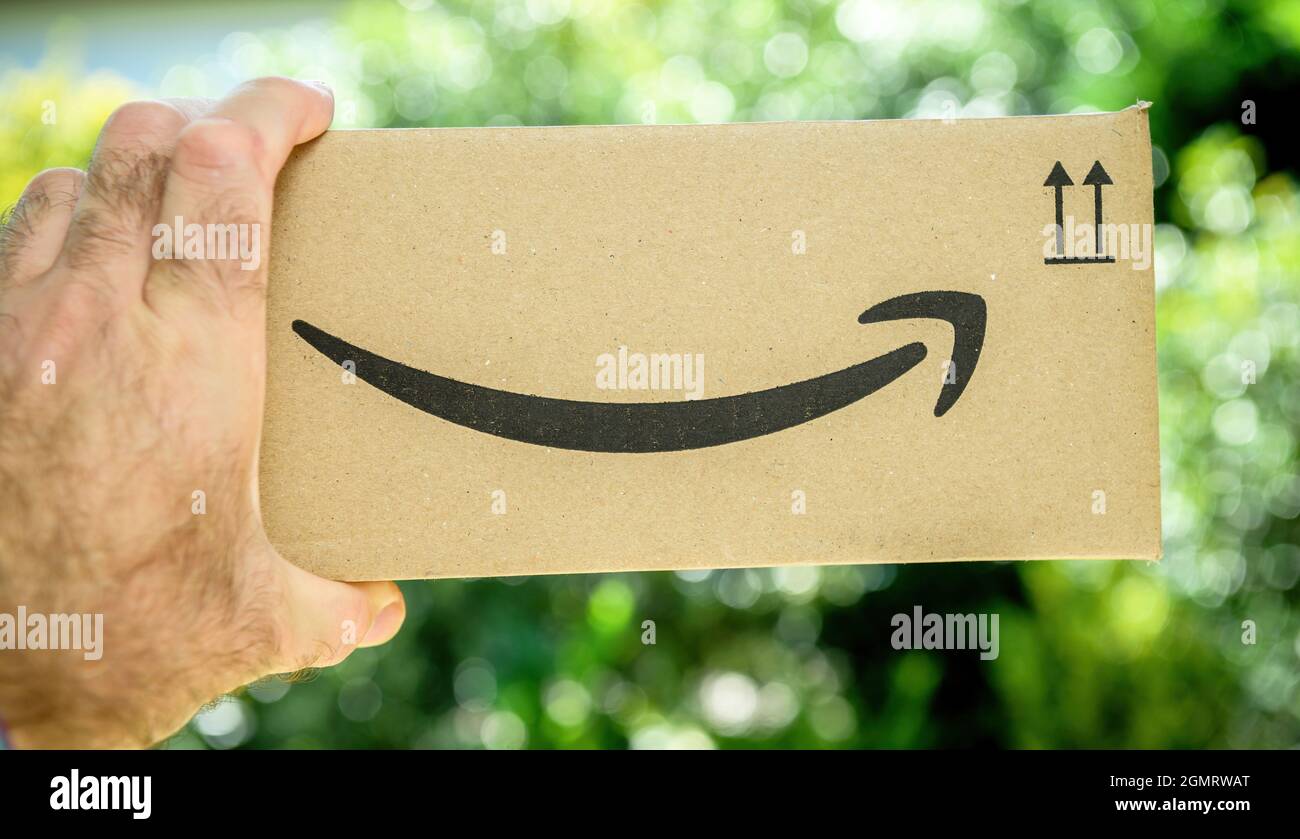 POV male hand holding new Amazon Prime cardboard parcel Stock Photo - Alamy