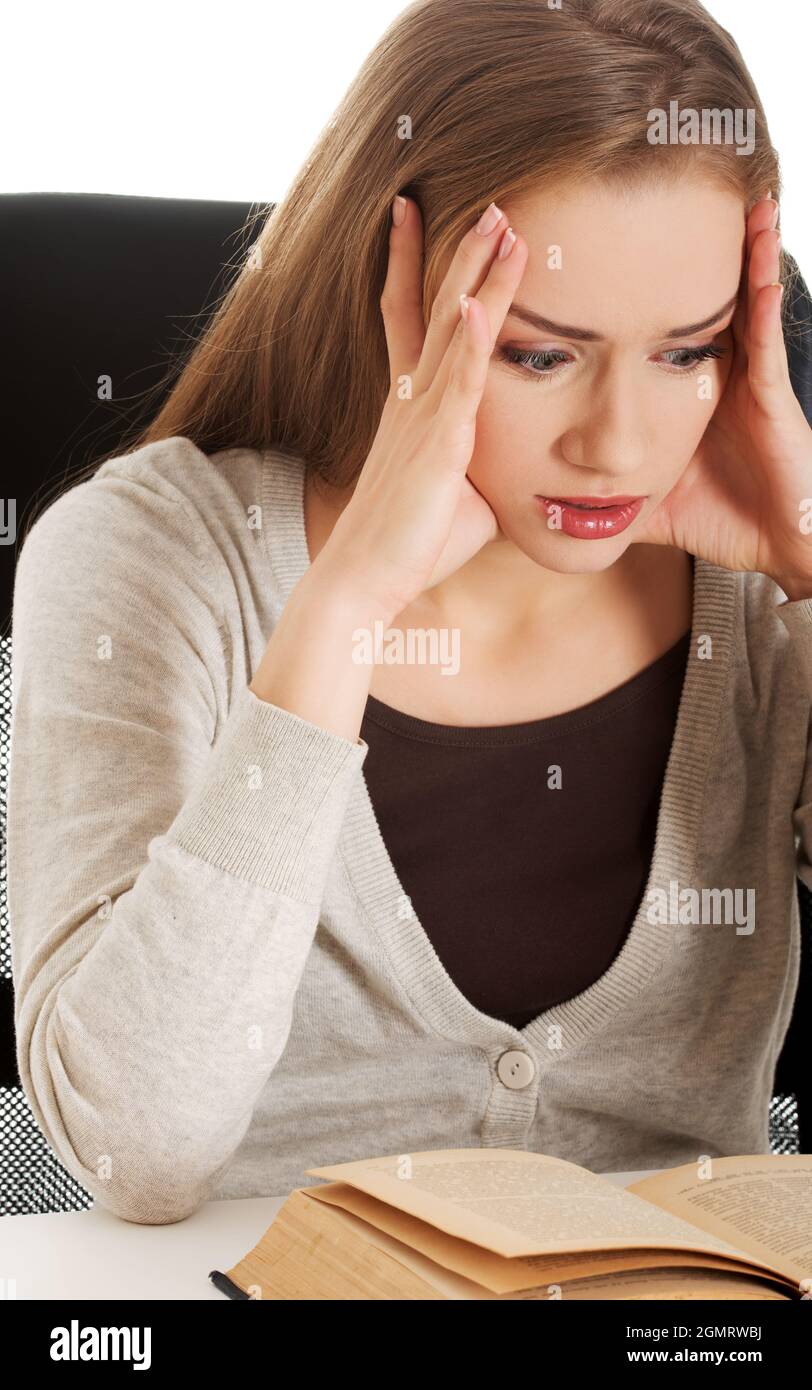 Vertical shot of blonde Caucasian woman tired reading a book Stock ...