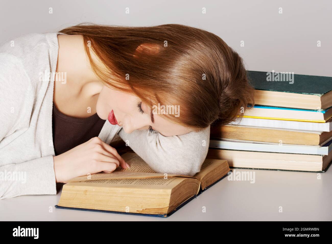 Blonde Caucasian woman tired reading a book Stock Photo - Alamy